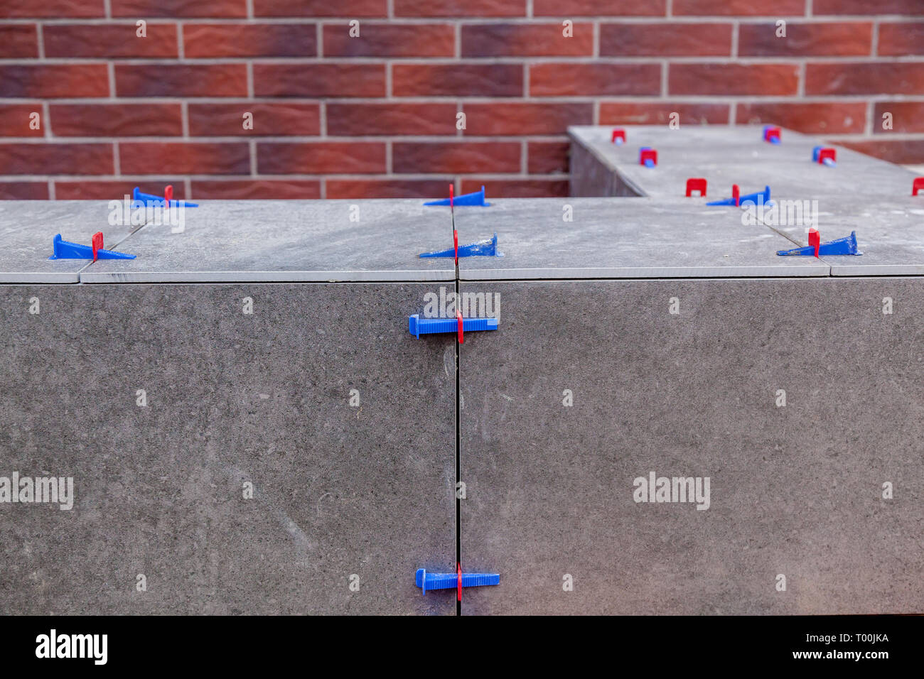 Laying ceramic tiles with leveling system. New tile alignment tools ...