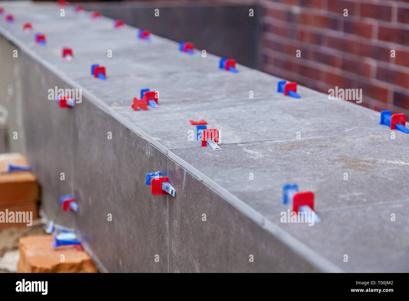 Laying ceramic tiles with leveling system. New tile alignment tools ...