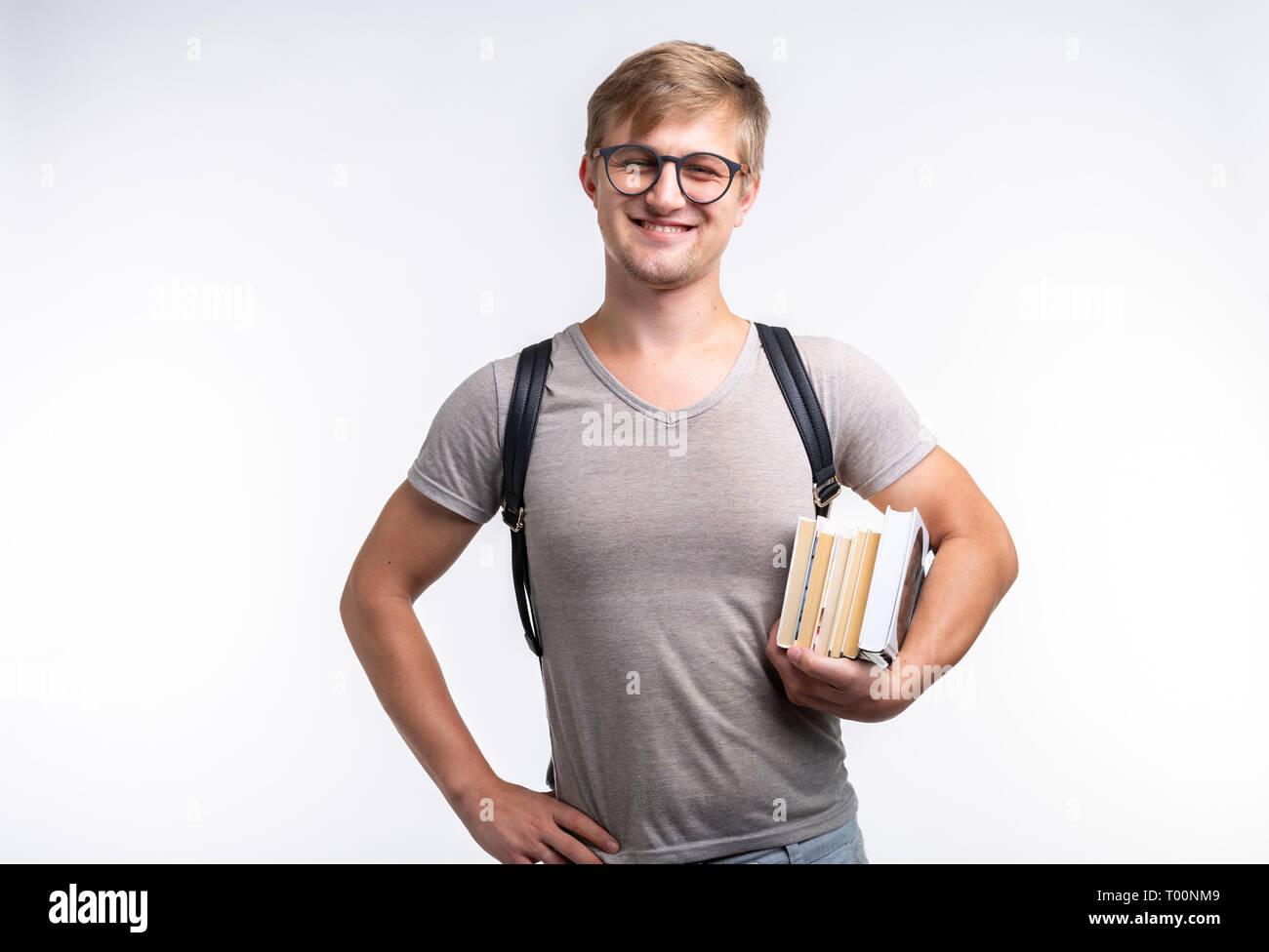Reading, education, people concept - a young student man holding many ...