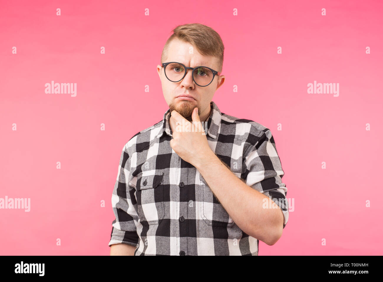 Geek, education, people concept - Thoughtful young man over the pink ...
