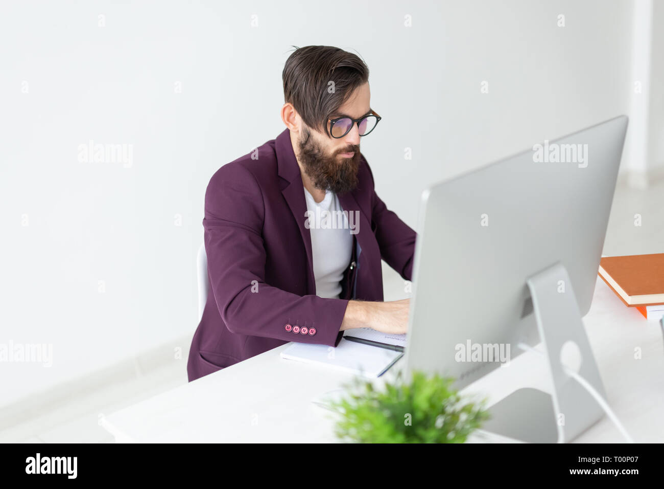 People and technology concept - Man sits and works at the computer ...