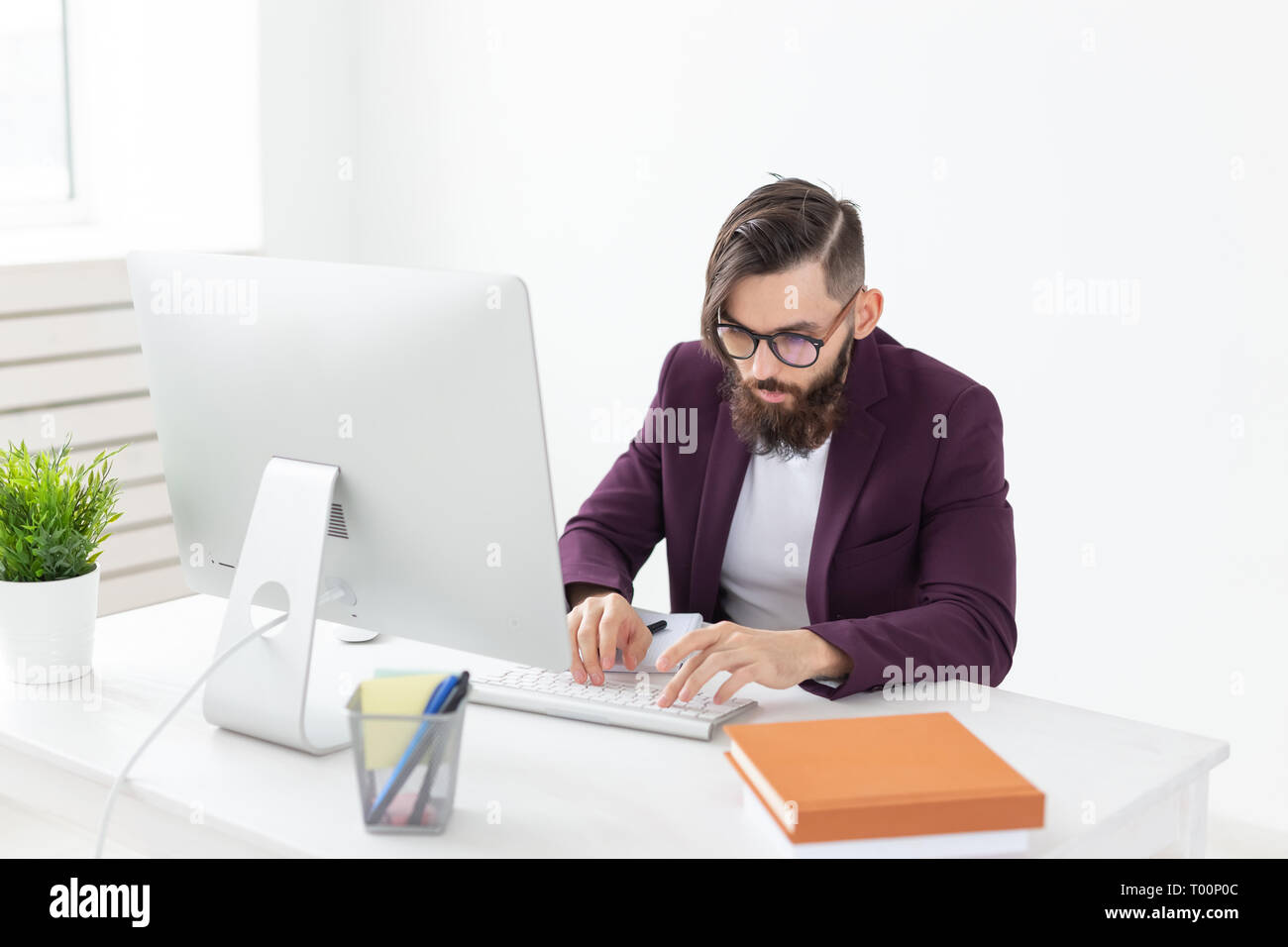 People and technology concept - Attractive man with beard working on at ...