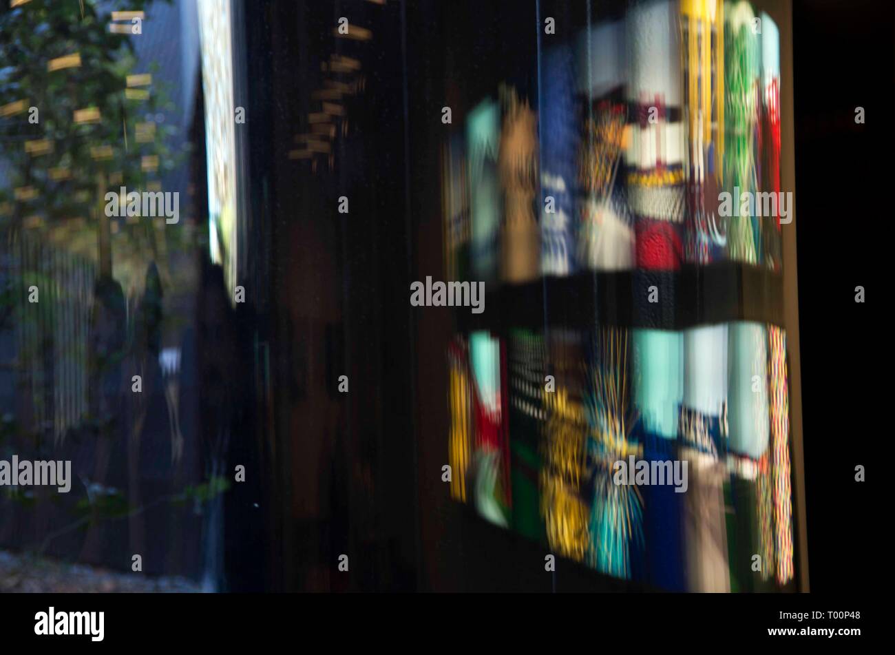 A curved window reflects an art exhibit at the De Young Museum in San ...