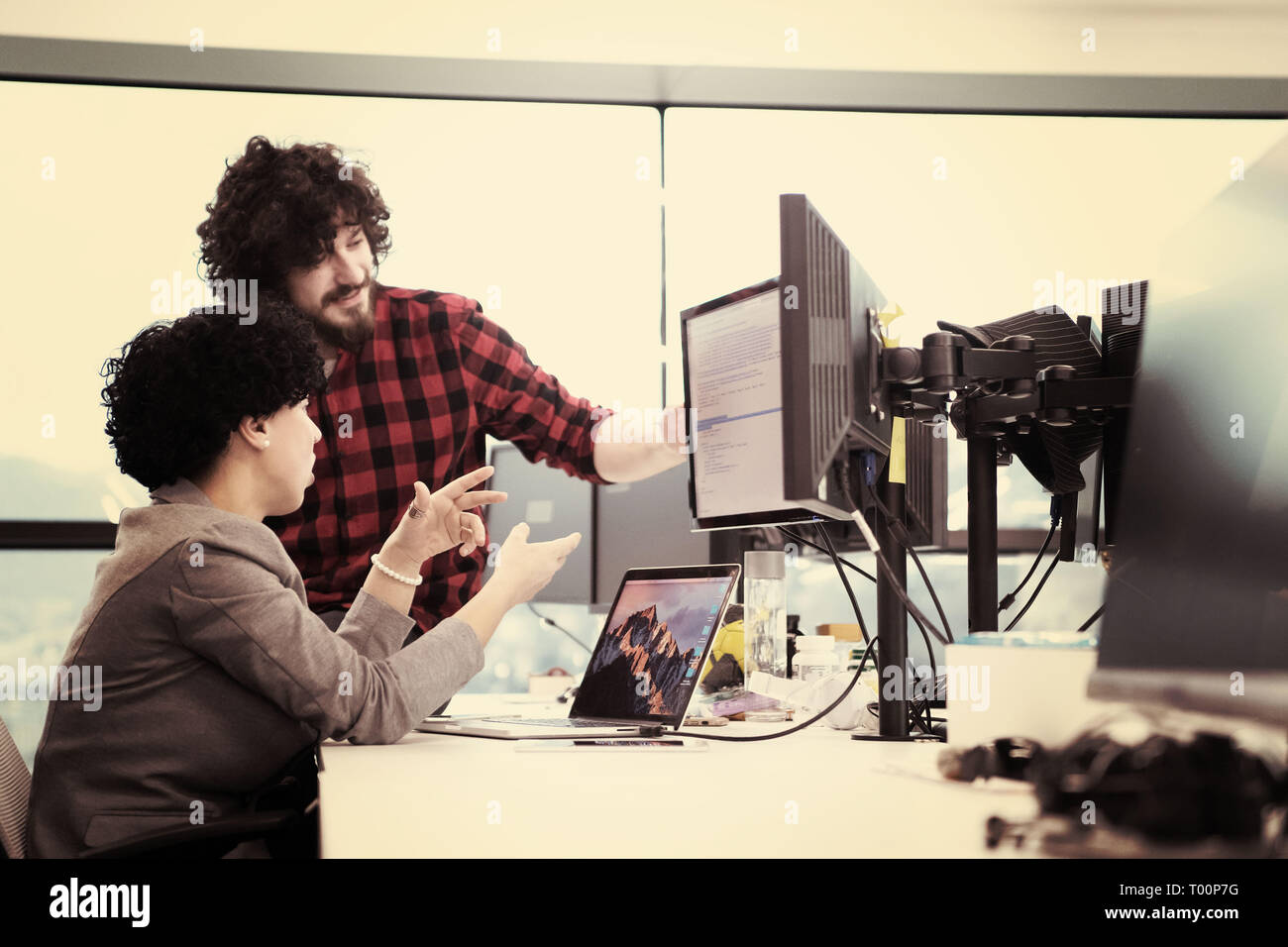 Young Software Developers Couple Using Laptop And Desktop Computer While Writing Programming