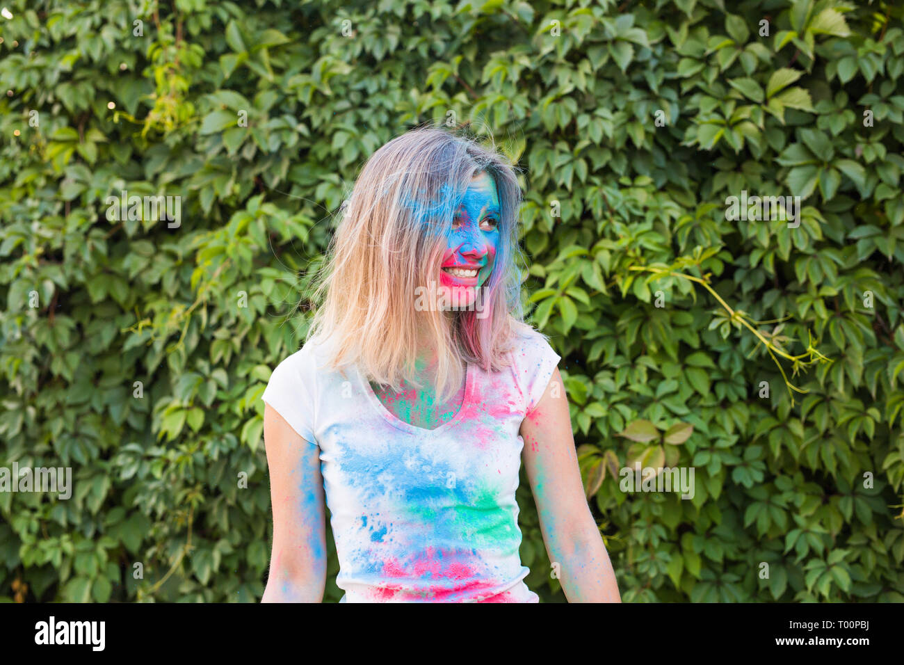 Holi festival, holidays and people concept - young woman having a fun ...