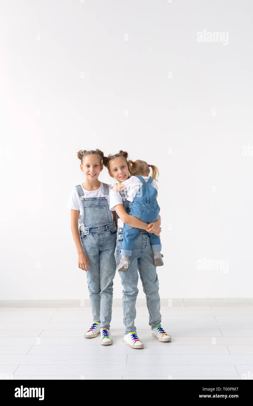 Family and love concept - Three sisters hugging over white background ...