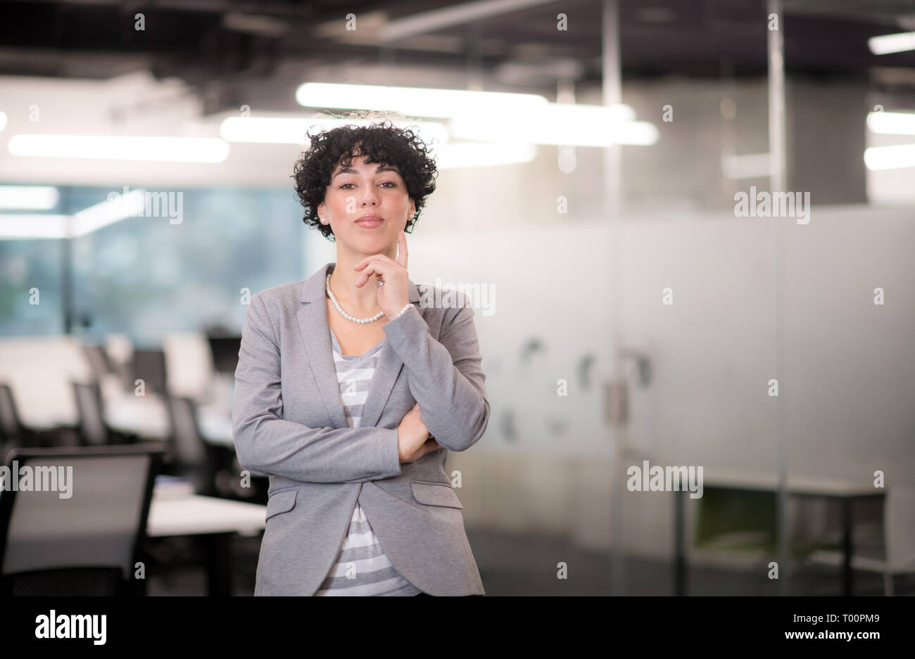 Portrait of successful female software developer with a curly hairstyle ...