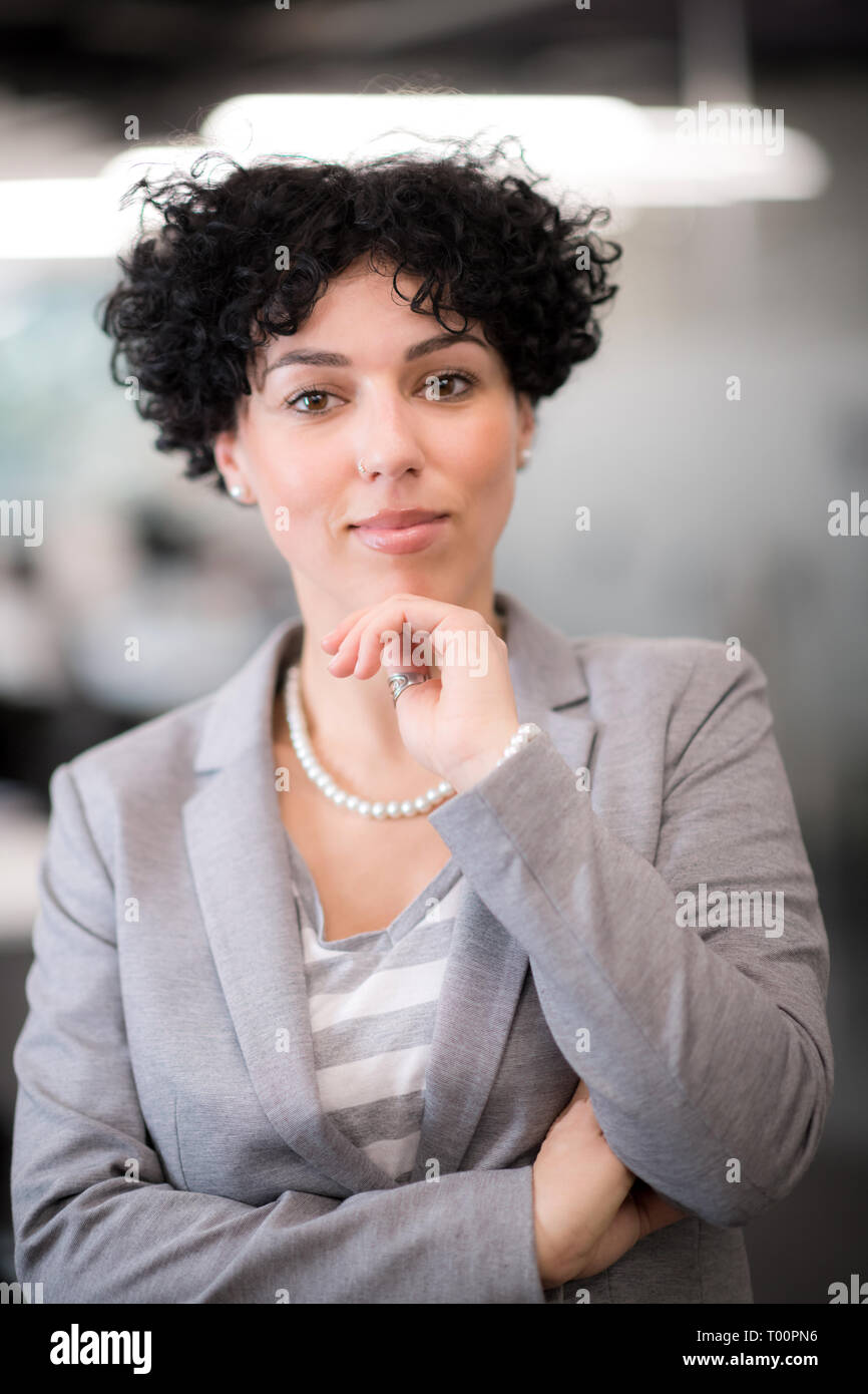 Portrait of successful female software developer with a curly hairstyle ...