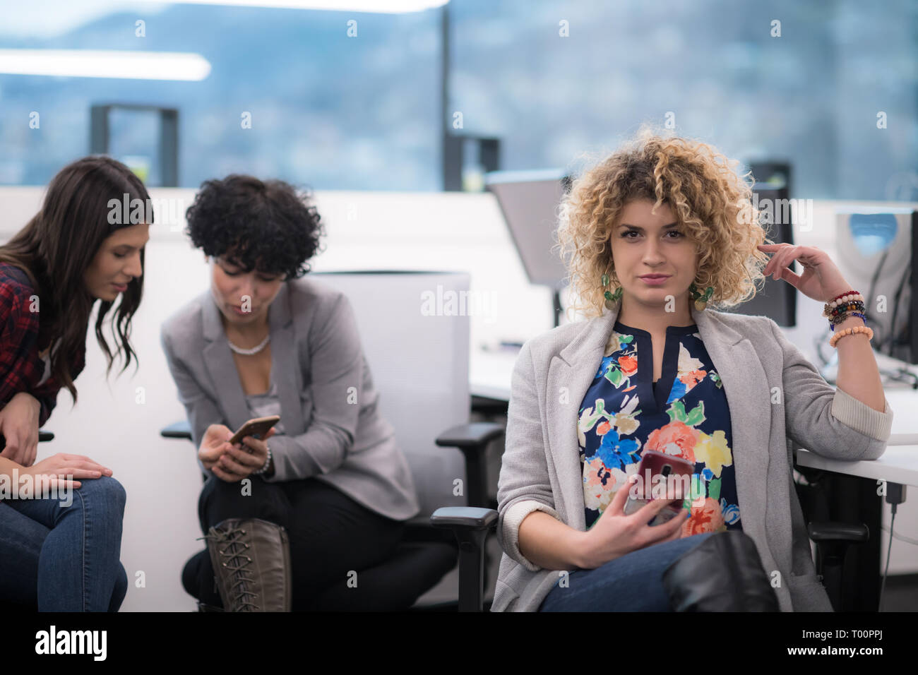 Portrait of successful female software developer with a curly hairstyle ...
