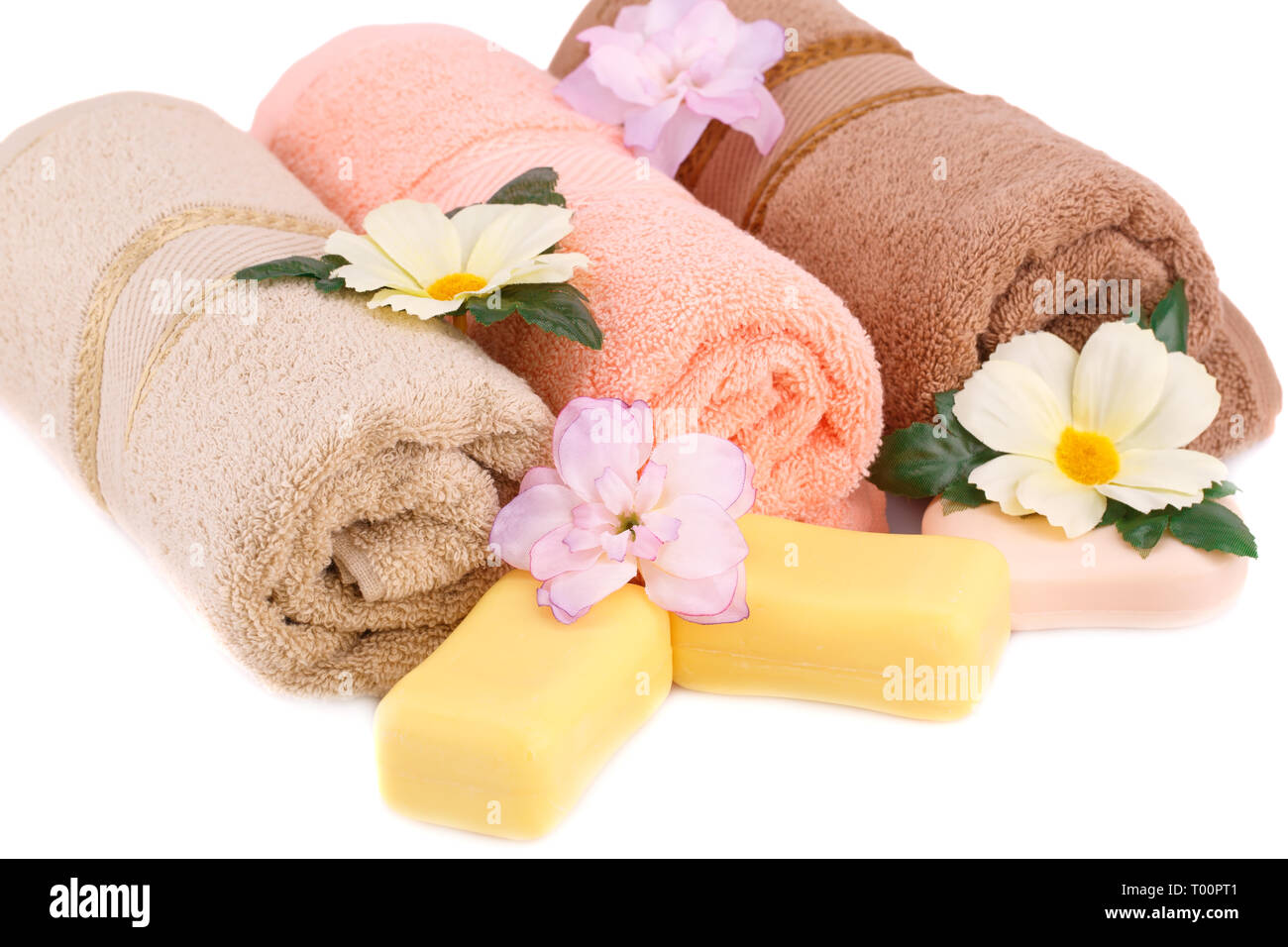 Rolled towels, soaps and flowers on white background Stock Photo - Alamy