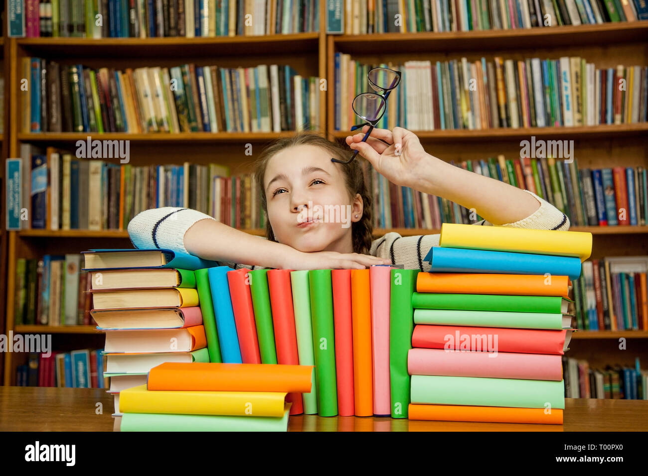 Girl dreams with books in the library Stock Photo - Alamy