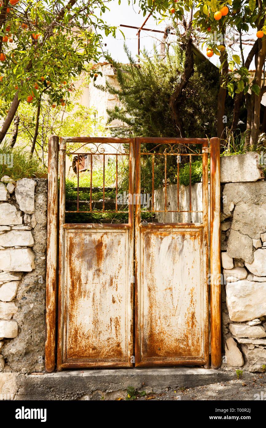 Old rusty gate and fruit trees in Limnatis village, Cyprus Stock Photo ...