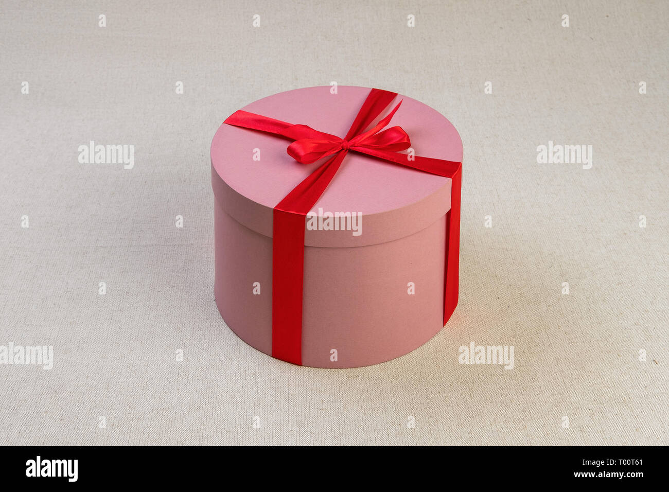 Round pink giftbox with red ribbon Stock Photo - Alamy