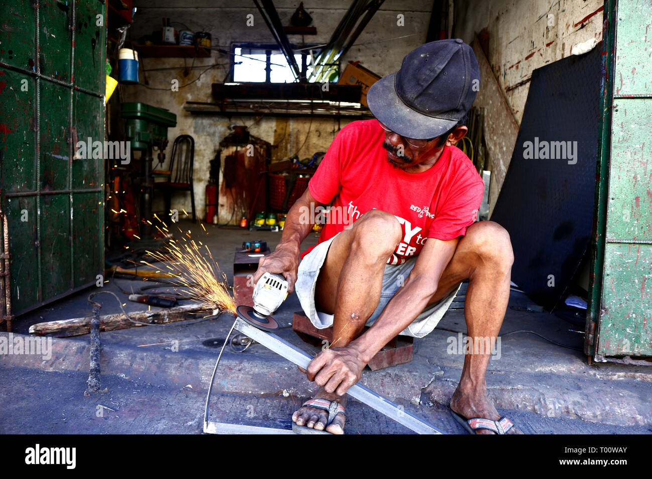 ANTIPOLO CITY, PHILIPPINES - MARCH 9, 2019: A machine shop worker uses ...