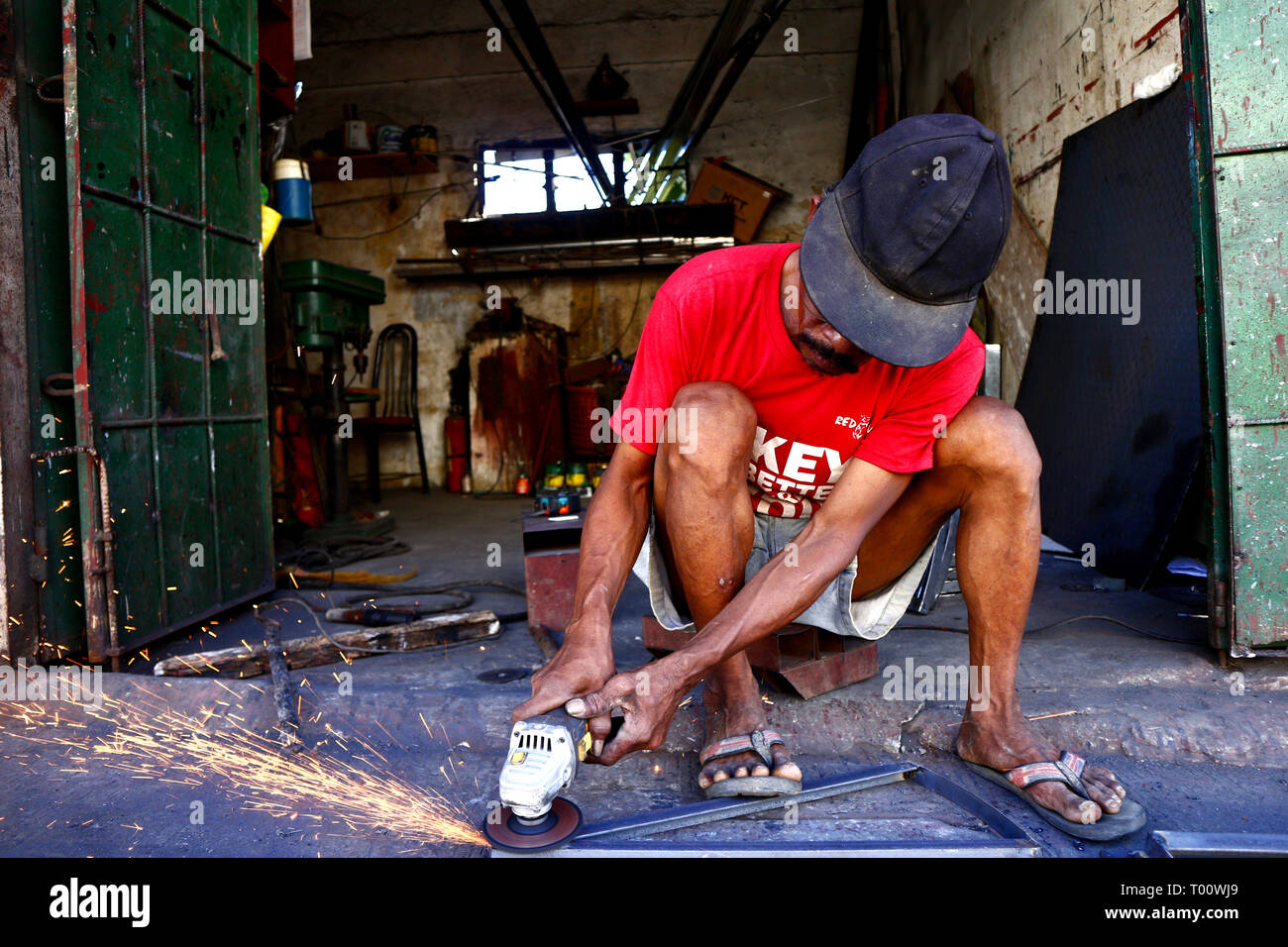 ANTIPOLO CITY, PHILIPPINES - MARCH 9, 2019: A machine shop worker uses ...