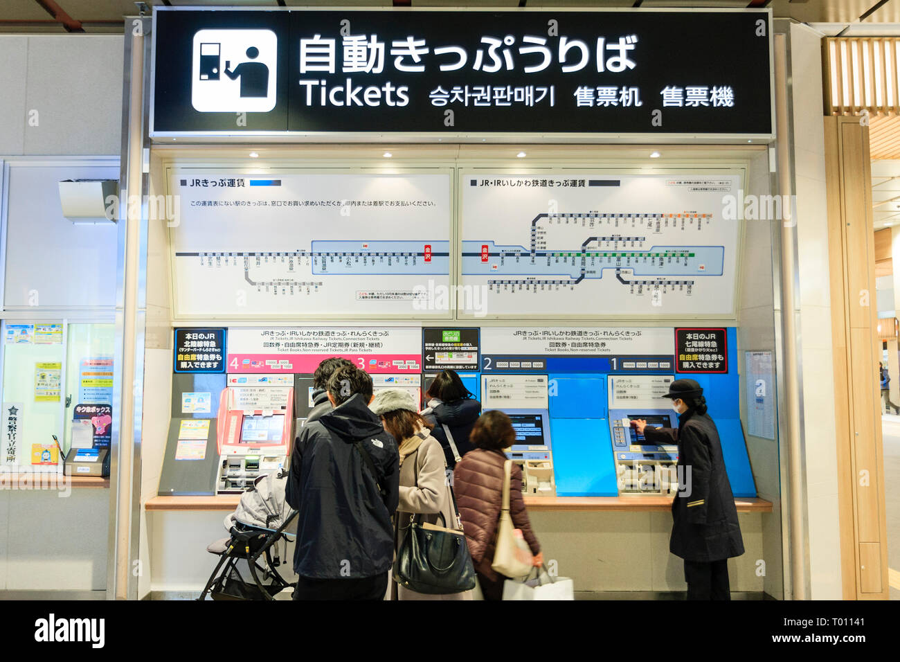 Kanazawa station, interior. People, commuters, at ticket machines ...