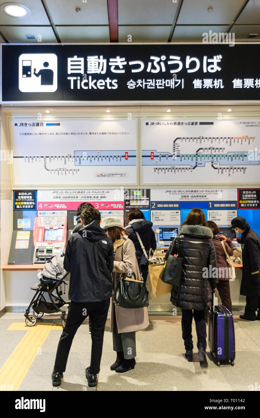 Kanazawa station, interior. People, commuters, at ticket machines ...