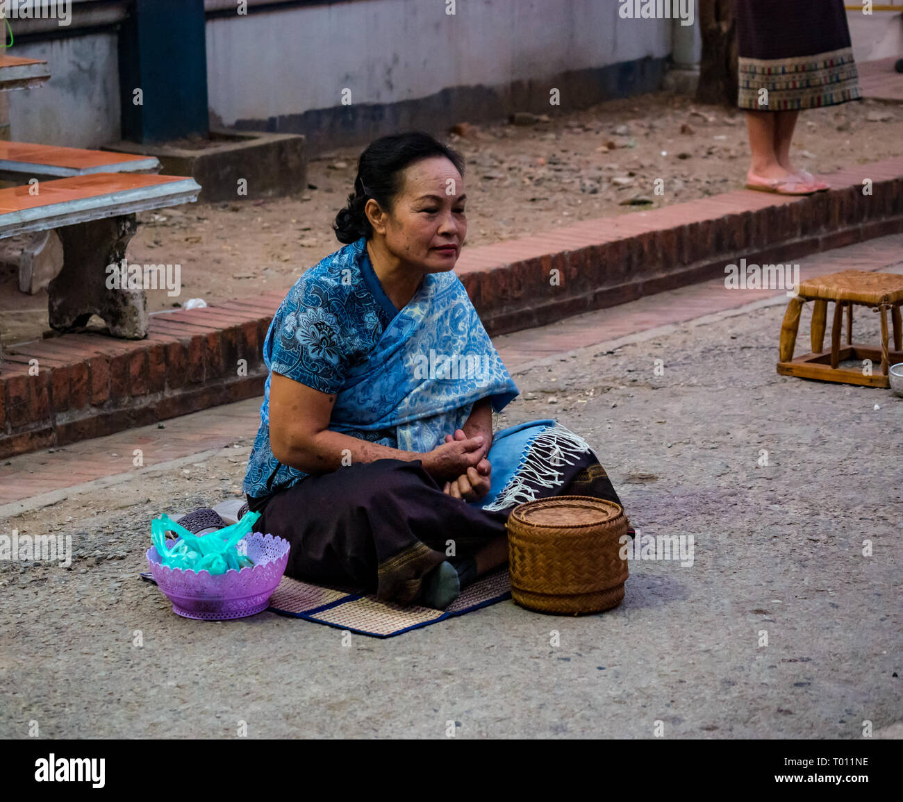 Woman waiting to give rice in morning alms giving ceremony to Buddhist ...