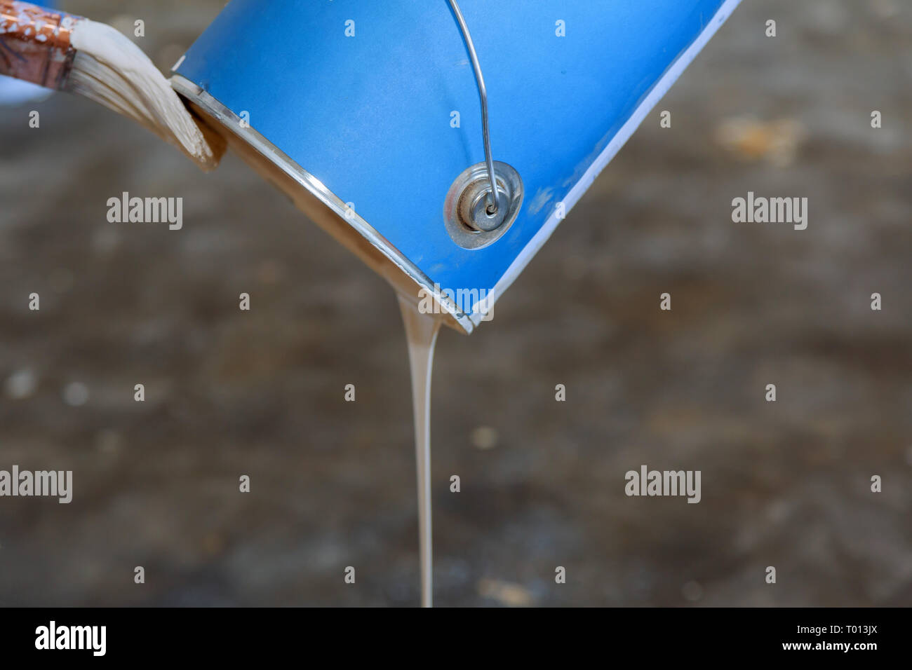 Man pouring paint into the painting tray for wall painting Stock Photo ...