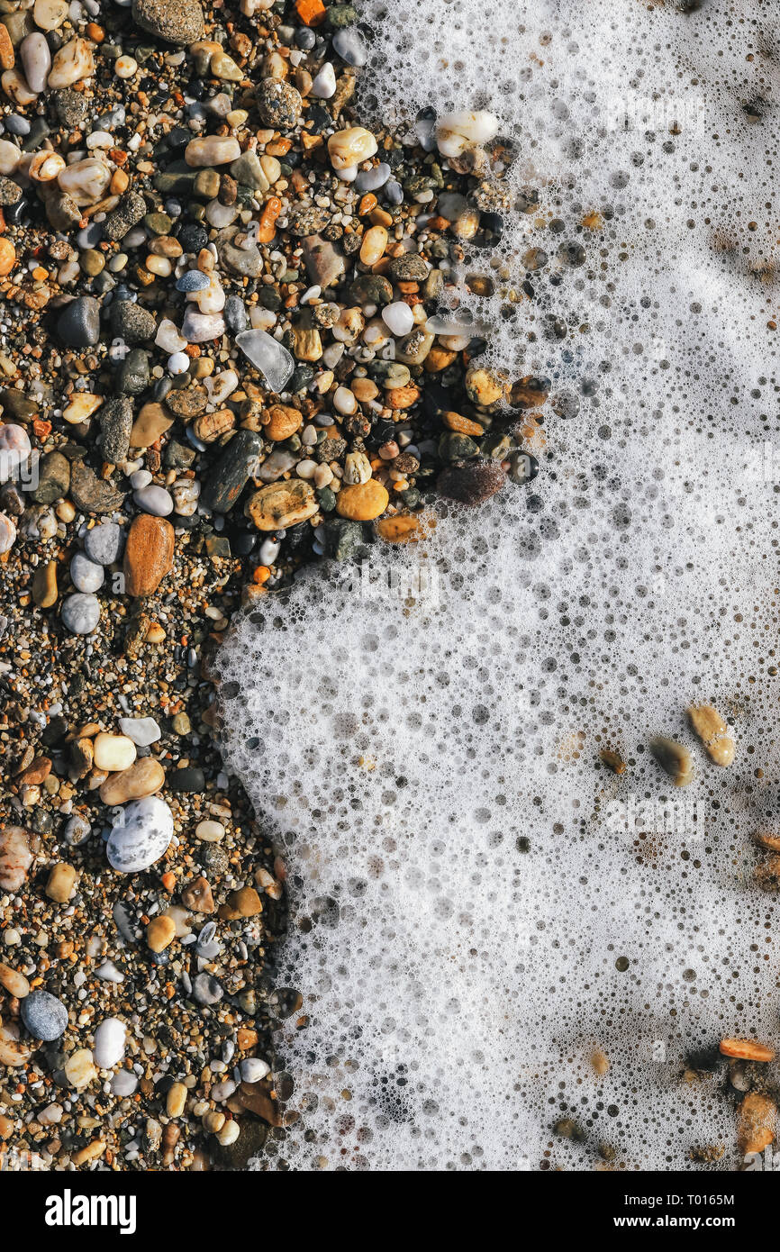 Sea stones on shore with sea wave foam background Stock Photo - Alamy