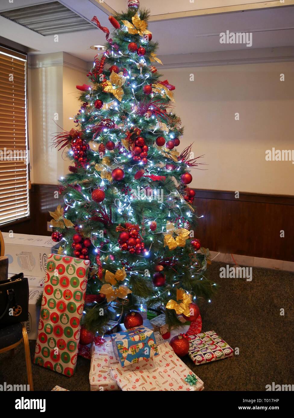 Christmas tree with wrapped gifts, beautifully decorated and lighted ...