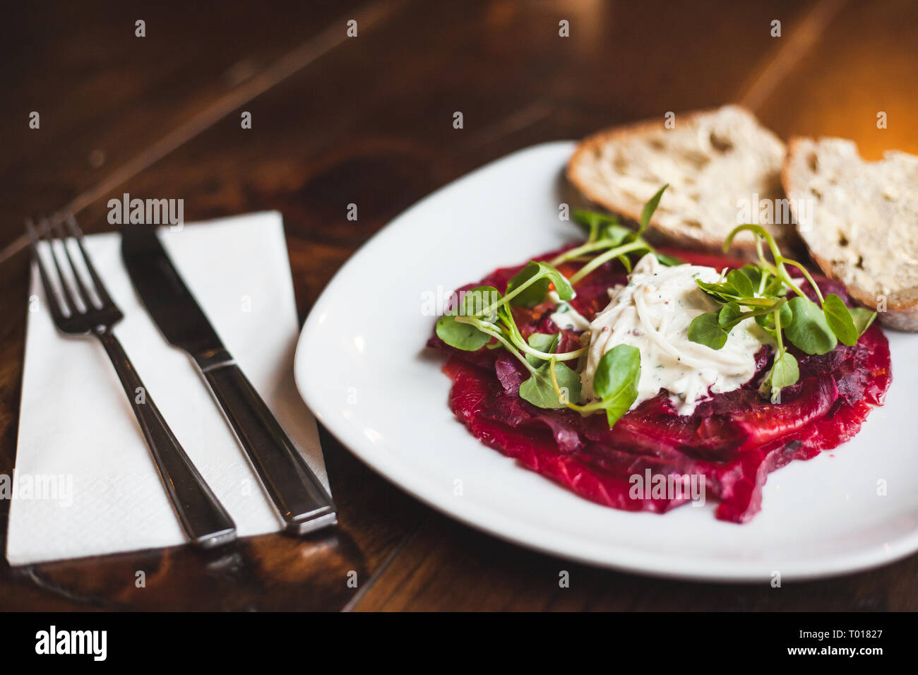 beetroot stained smoked salmon with crusty bread and salad garnish ...