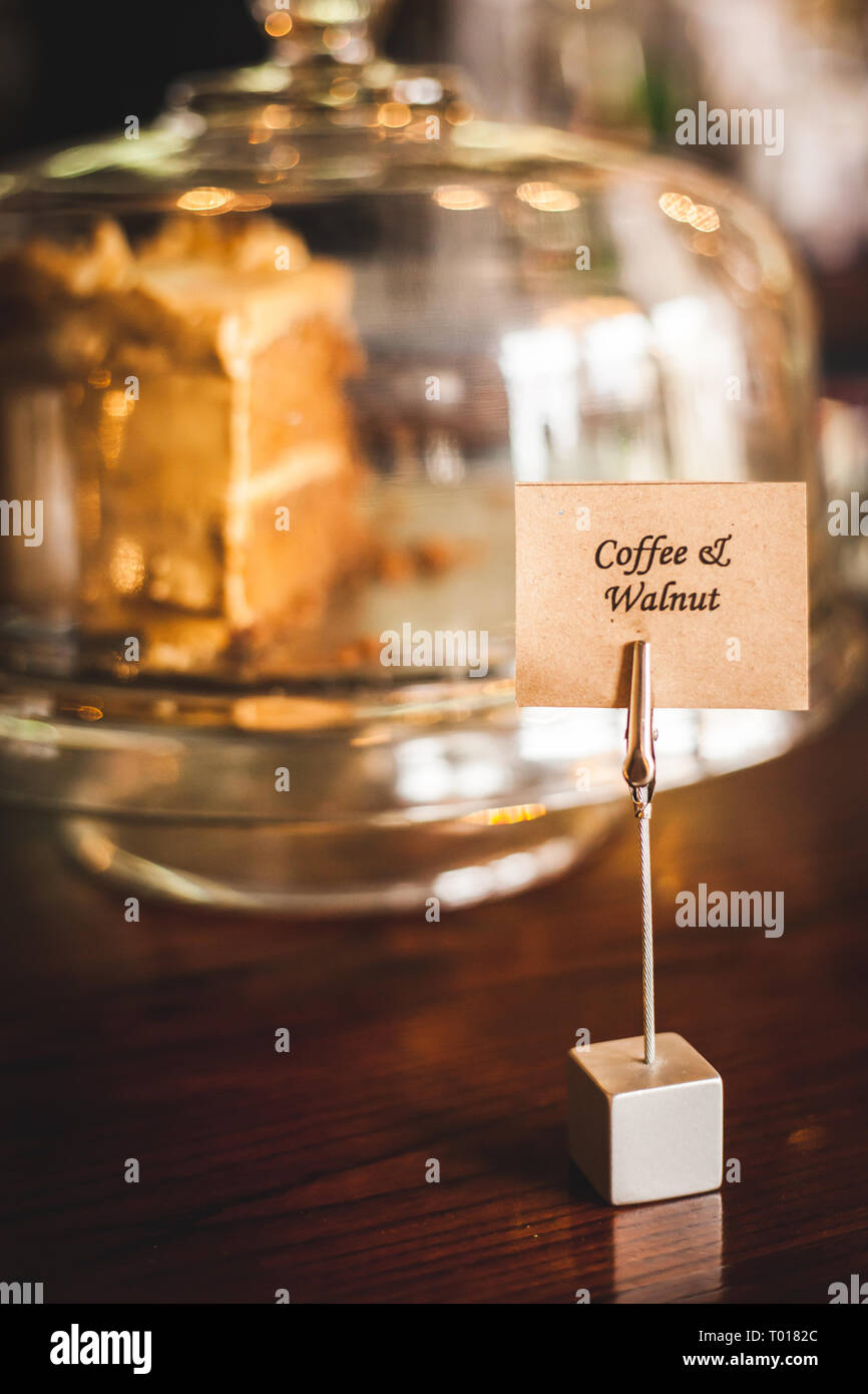 Coffee and Walnut Cake sign with a cake in a glass dome behind Stock ...