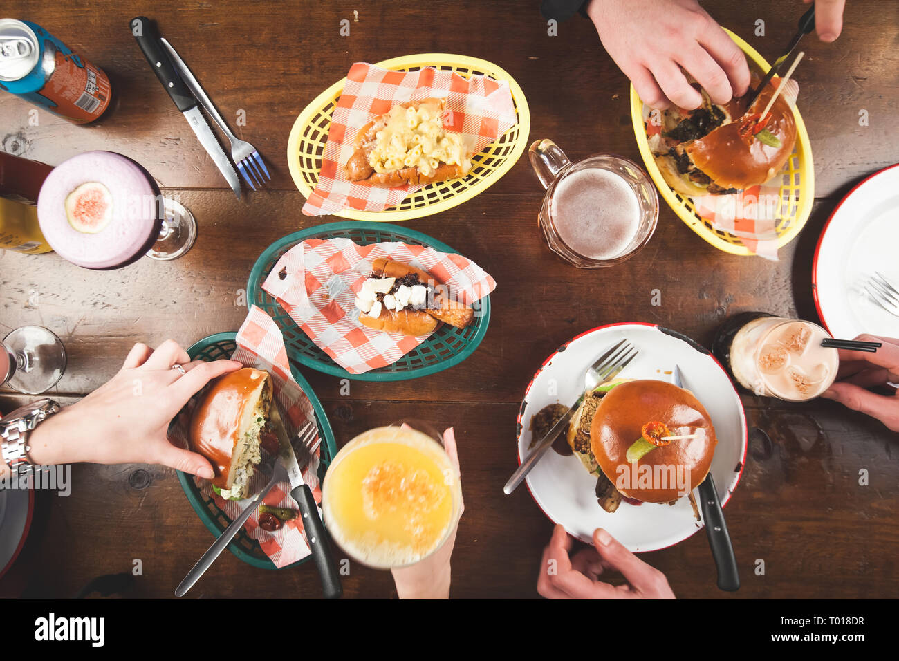 friends sharing bar food at the pub, from above, burgers, hotdogs and ...