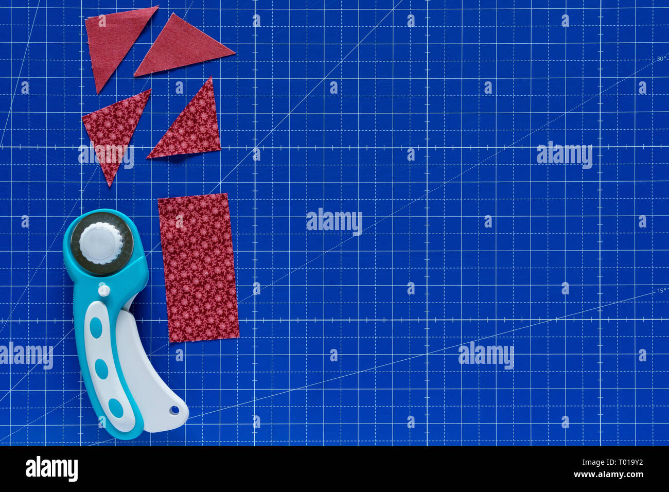 Cutting mat with rolling knife and pieces of fabric for quilting or ...