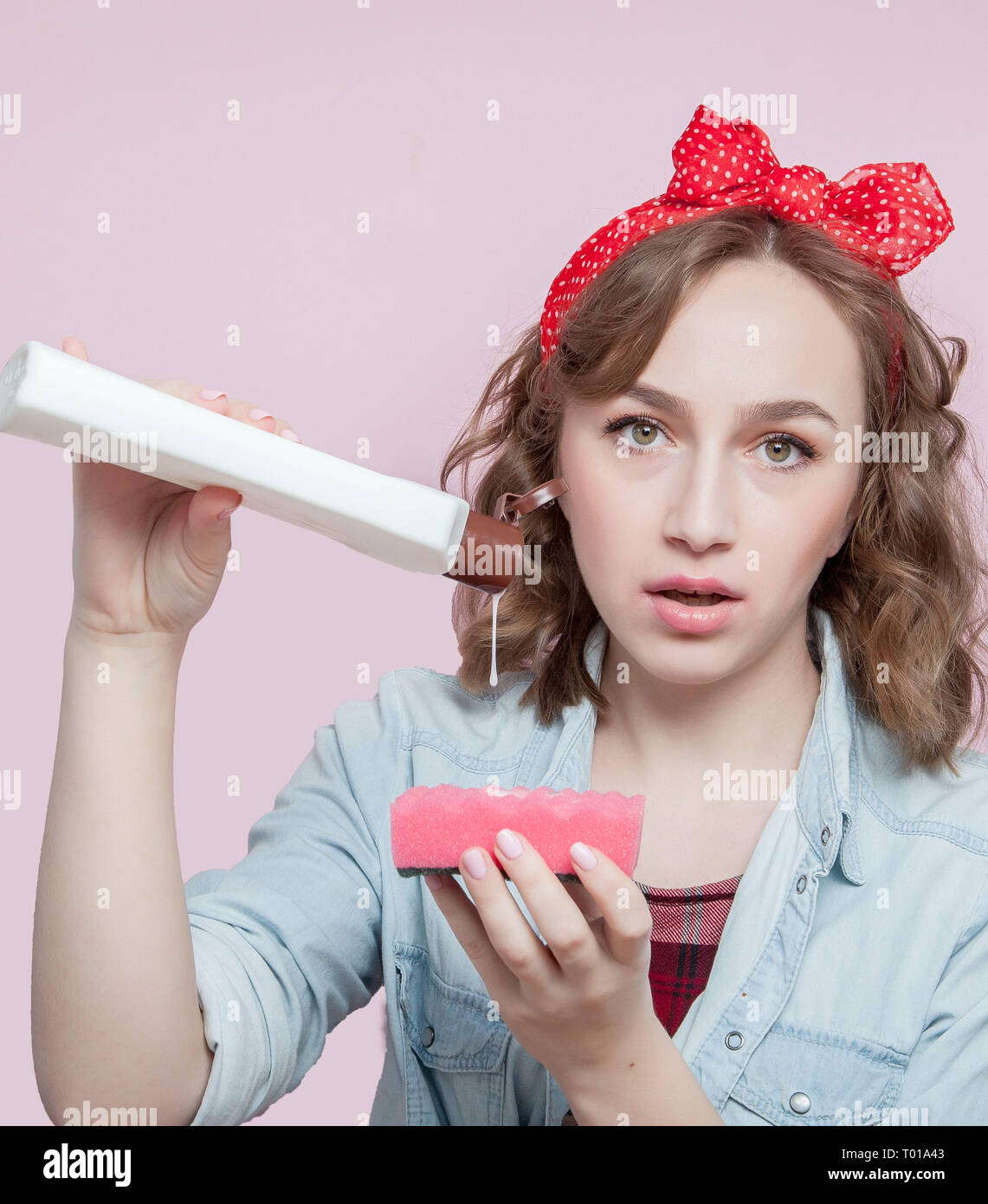 Beautiful young woman with pin-up make-up and hairstyle with cleaning ...