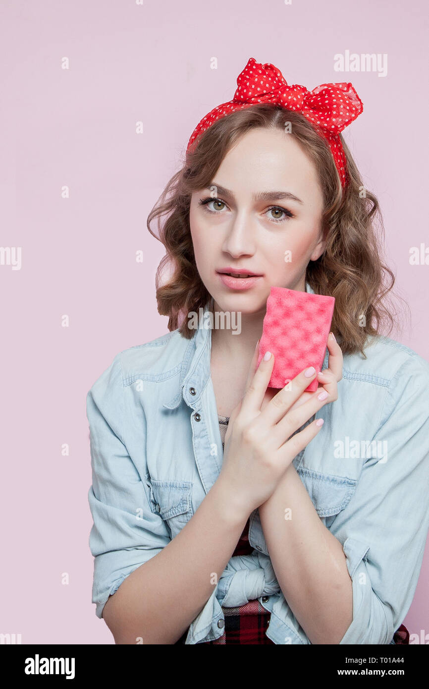 Beautiful young woman with pin-up make-up and hairstyle with cleaning ...