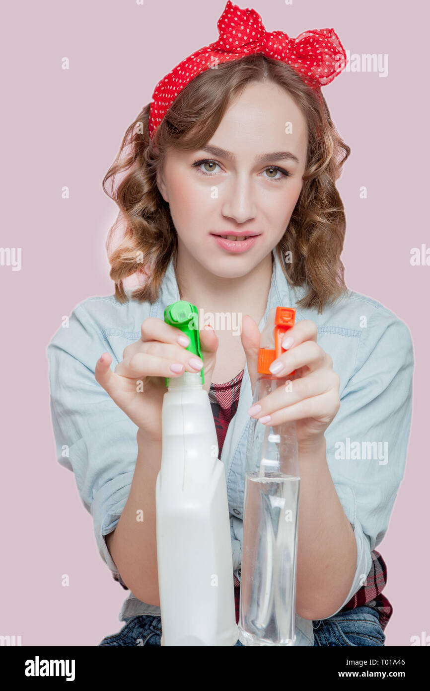 Beautiful young woman with pin-up make-up and hairstyle with cleaning ...