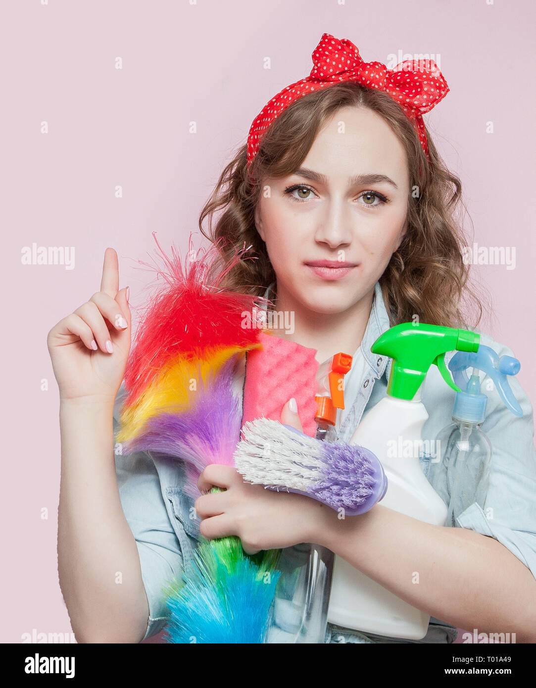 Beautiful young woman with pin-up make-up and hairstyle with cleaning ...
