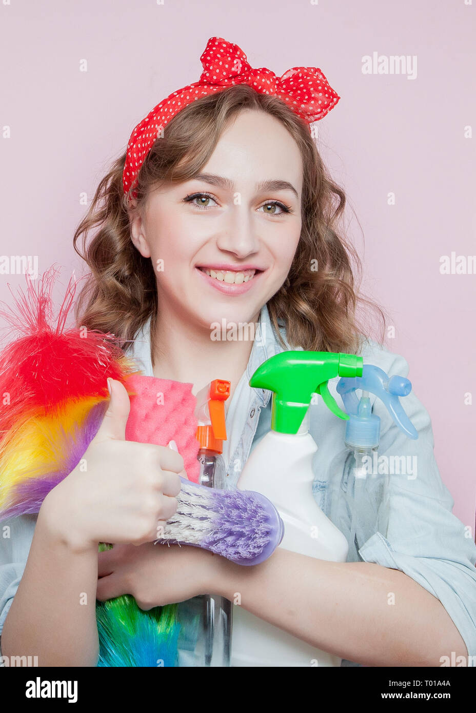Beautiful young woman with pin-up make-up and hairstyle with cleaning ...