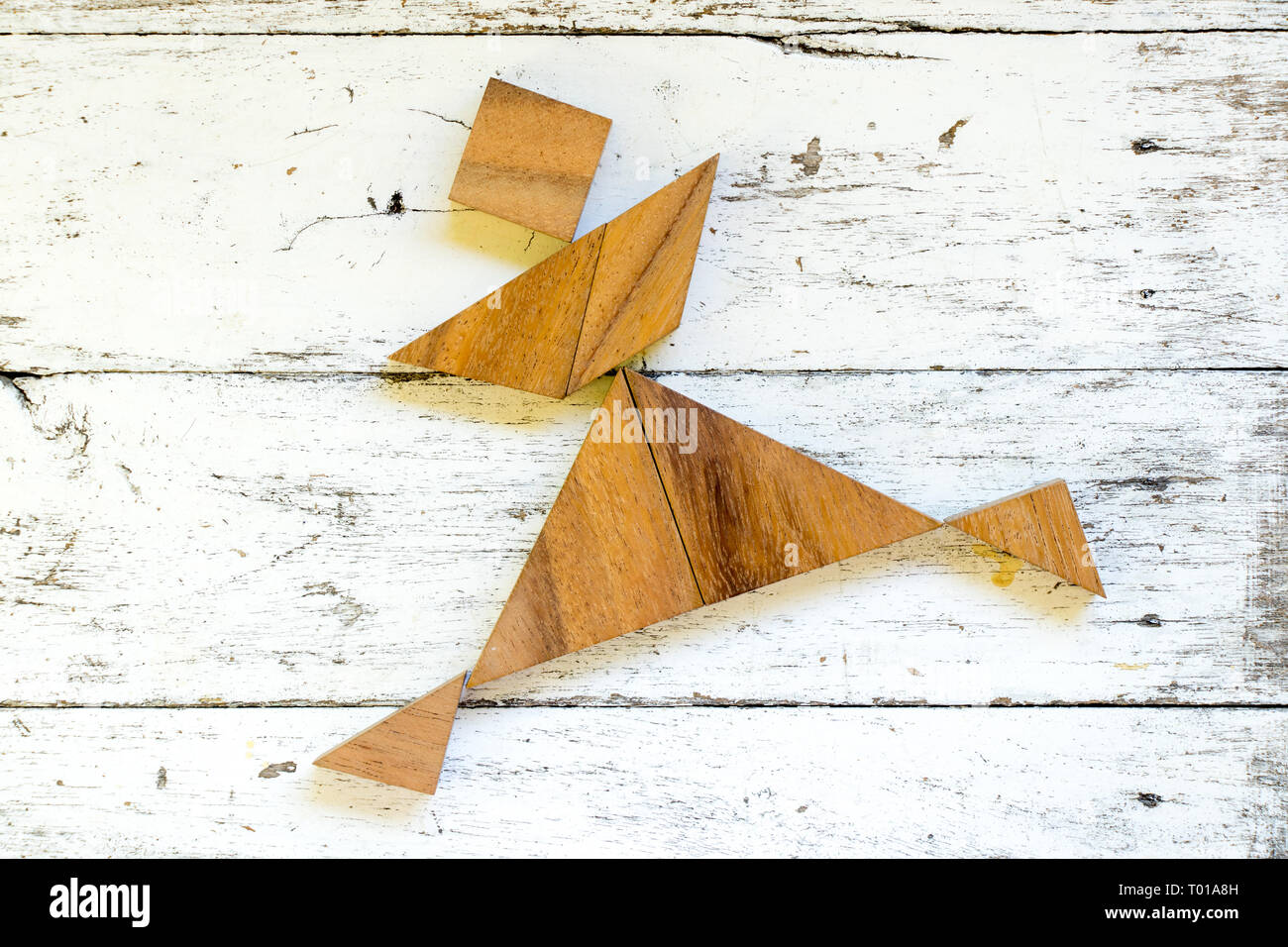 Tangram puzzle in happy running man shape on old white wood background ...