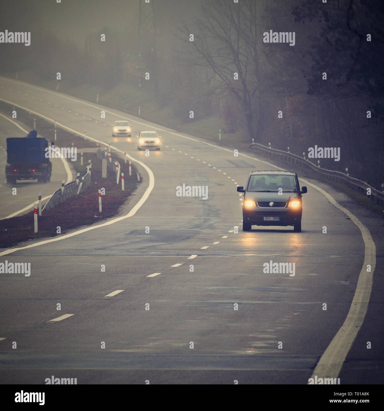 Bad weather driving - foggy hazy country road. Motorway - road traffic ...