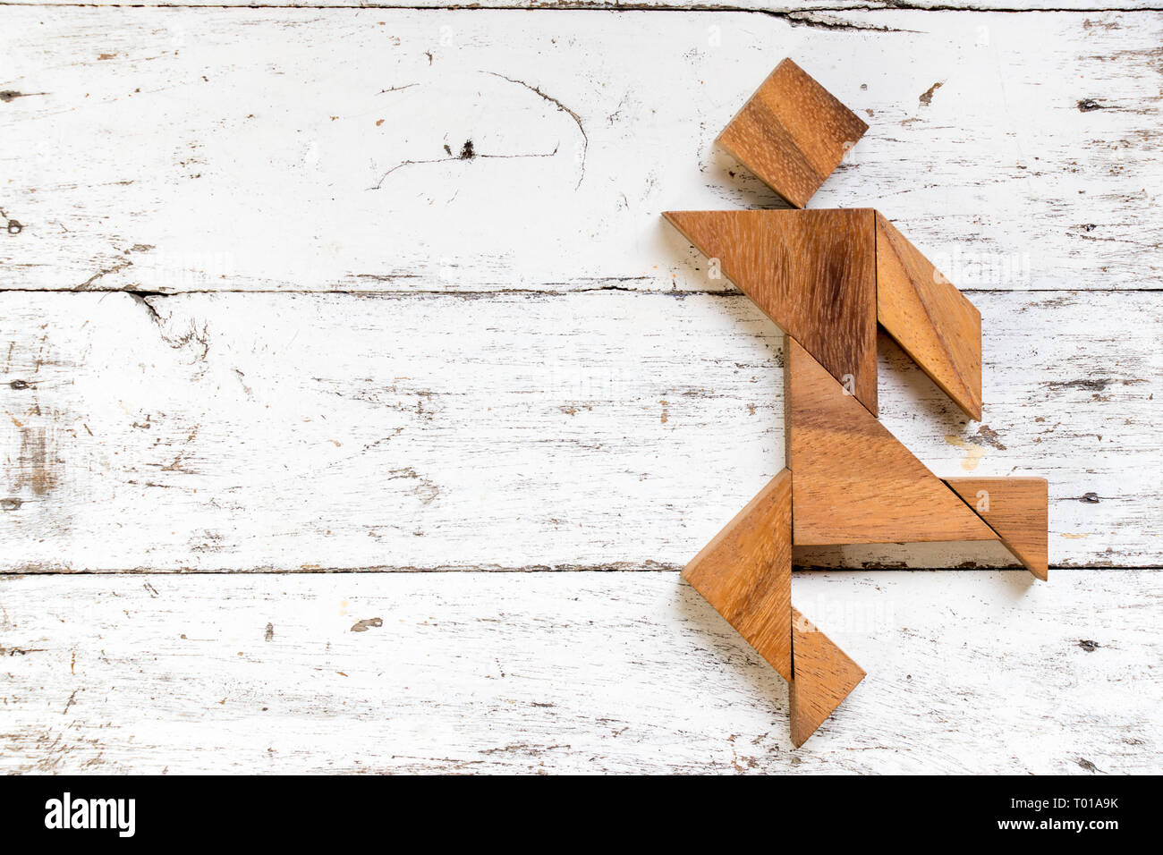 Tangram puzzle in happy running man shape on old white wood background ...