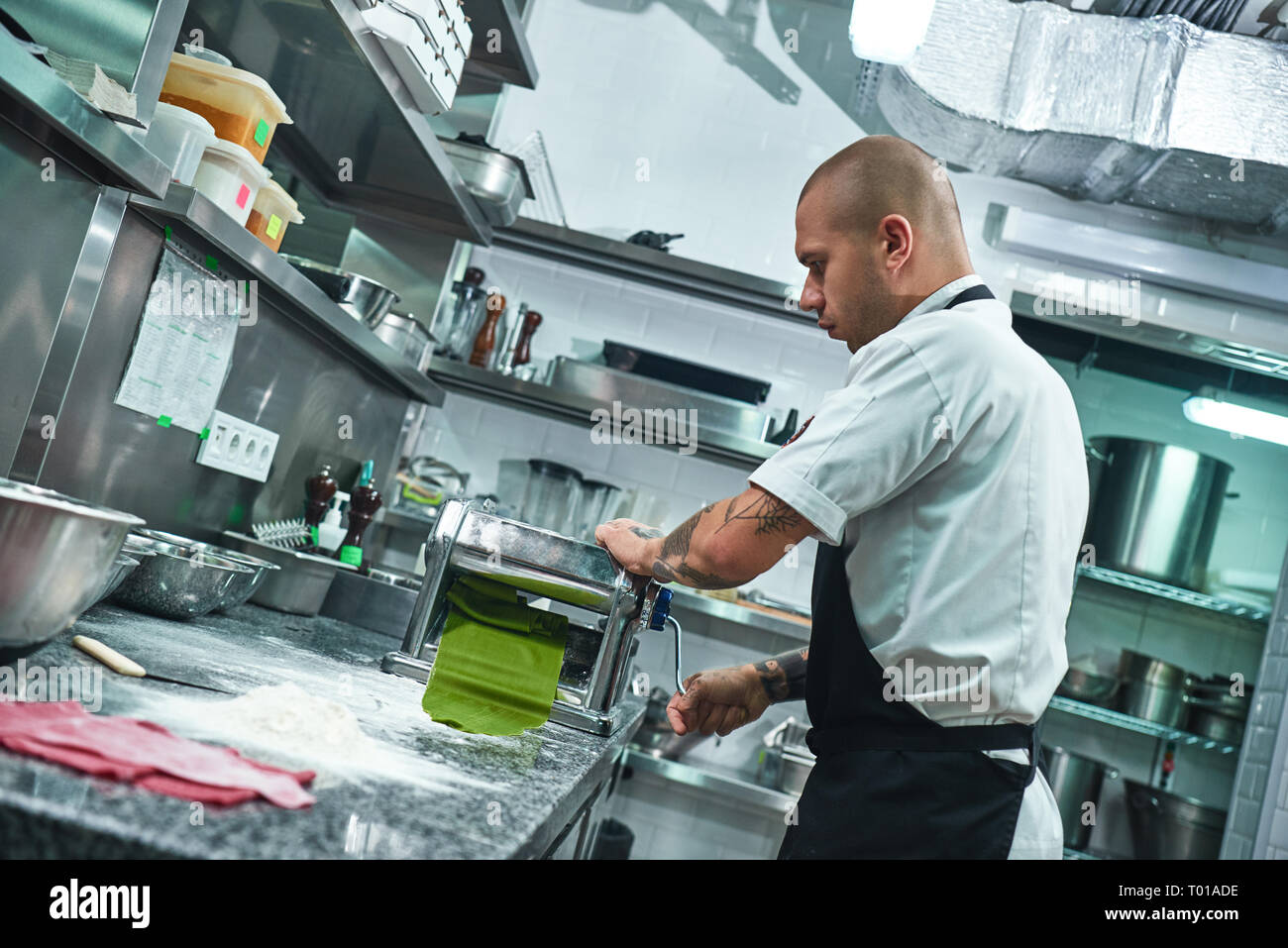 Traditional italian food. Side view of handsome chef rolling a green ...