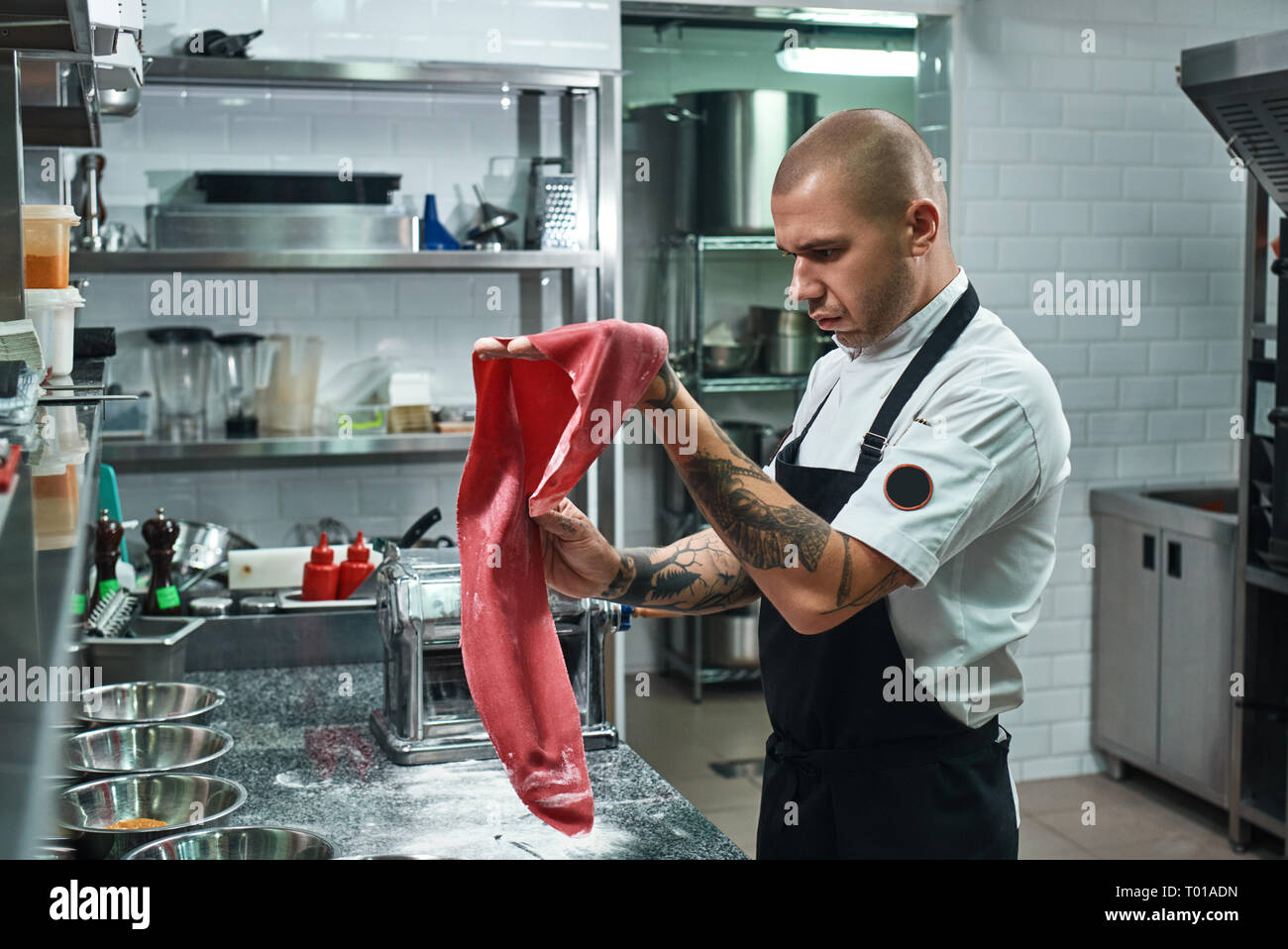 Italian food. Handsome professional chef holding a dough for homemade ...