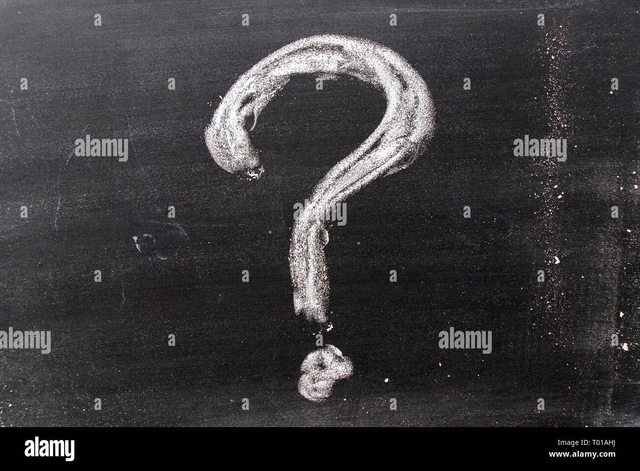 White color chak hand drawing in question mark shape on blackboard ...
