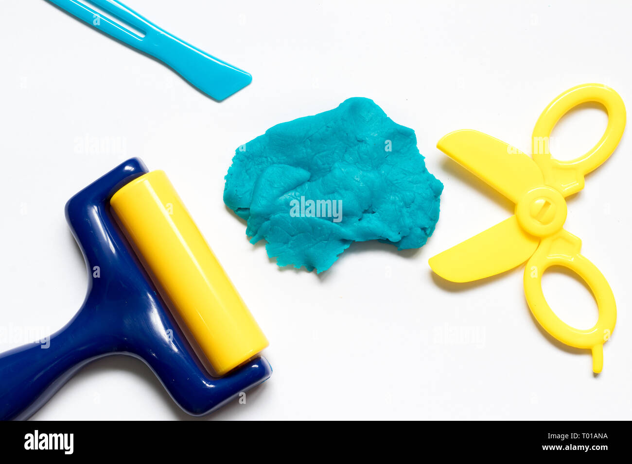 Blue dough with plastic kids equipment (roller, scissors, knife) for ...