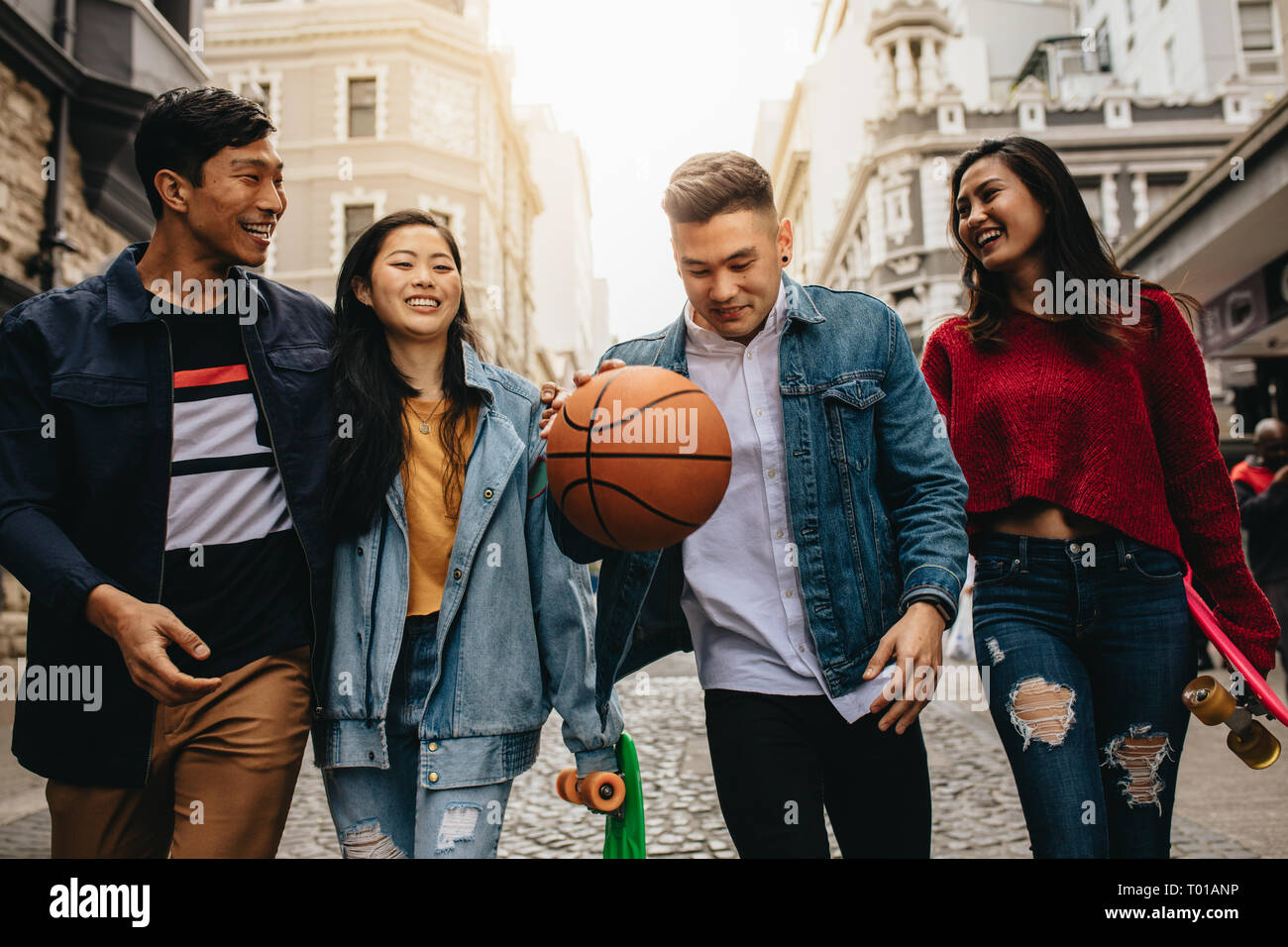 Group of friends walking together on the street, with women holding ...