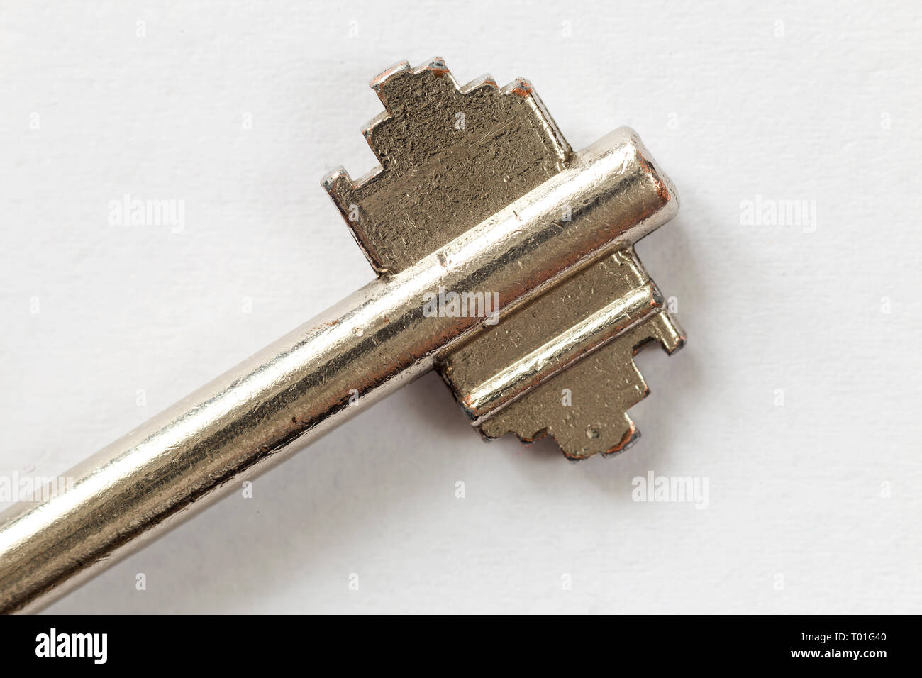 Close-up detail of old well-used steel key isolated on white copy space ...
