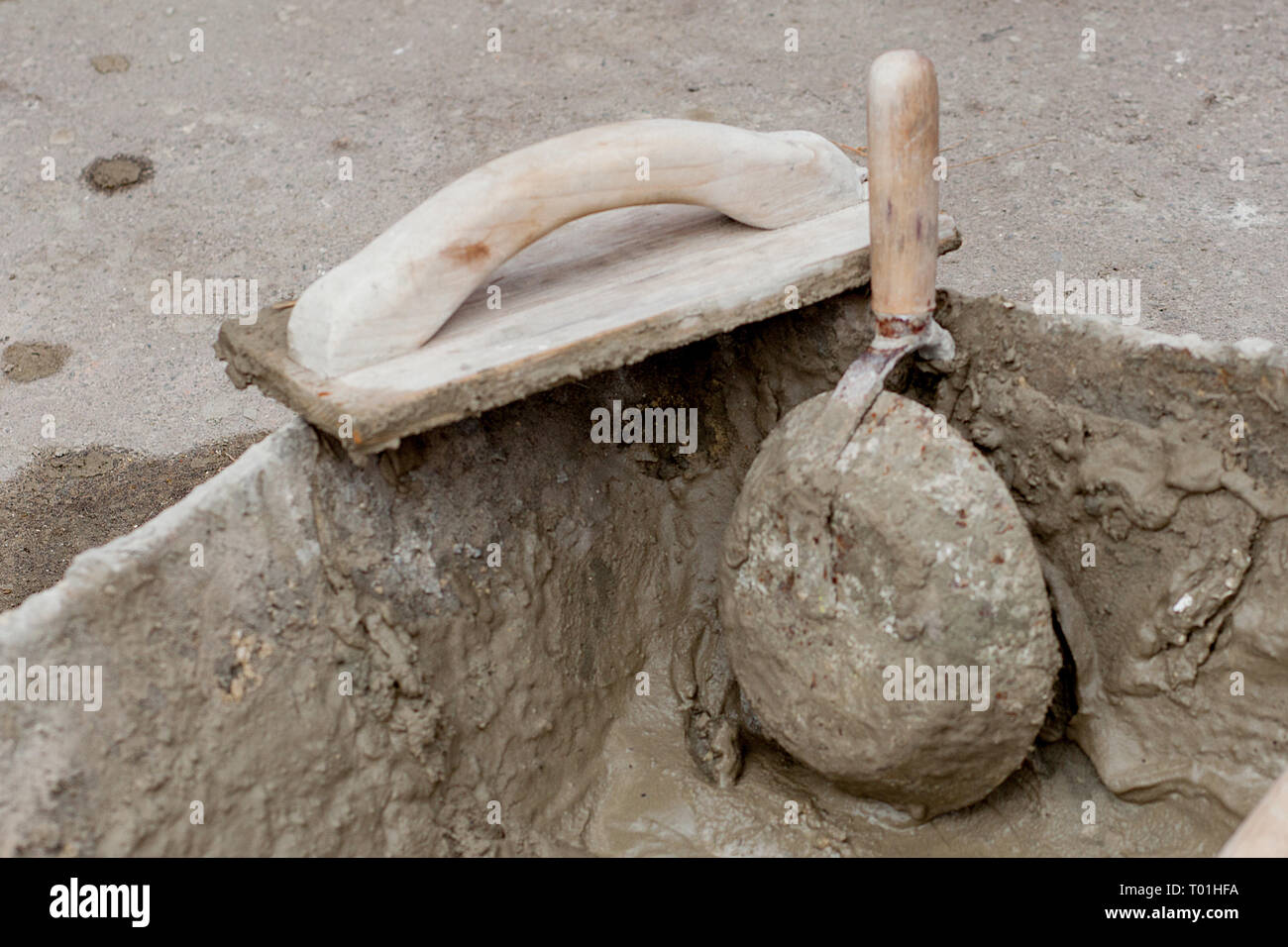 Bucket with plaster and metal building spatula. Above view and close up ...