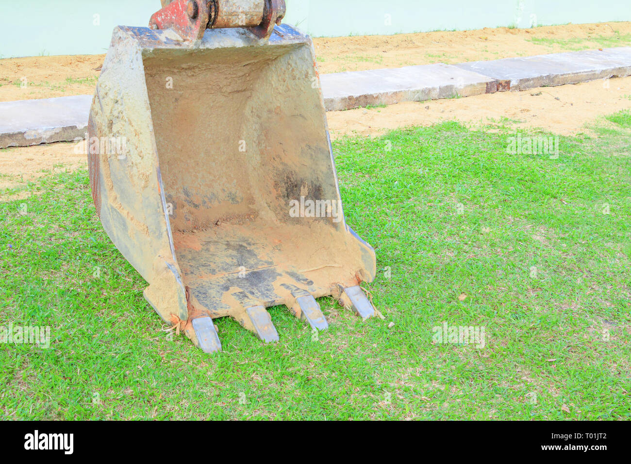 excavator bucket close up On the green grass Stock Photo - Alamy