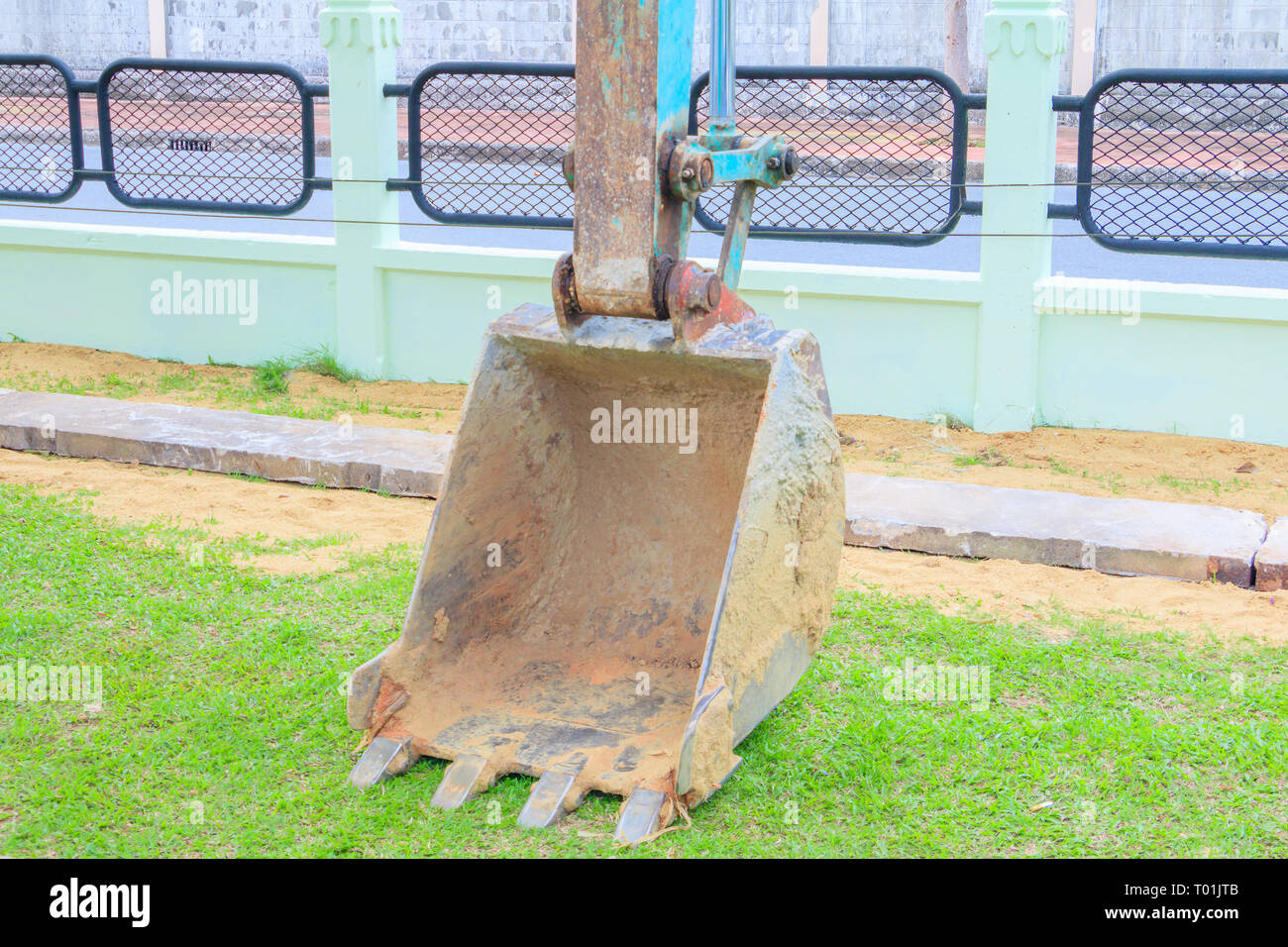 excavator bucket close up On the green grass Stock Photo - Alamy