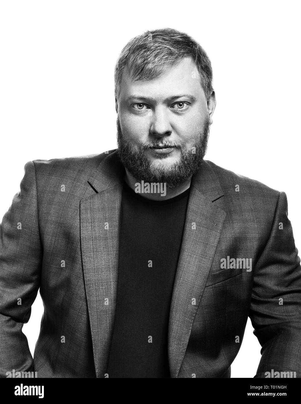Black and white portrait of a bearded man. Office style, jacket and t ...