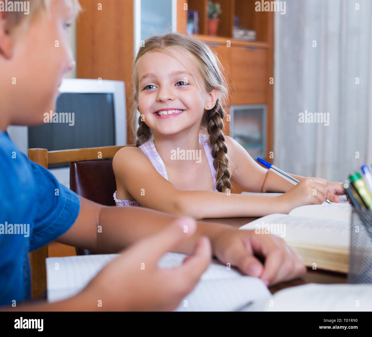 Portrait of smiling children with textbooks and notes in domestic ...