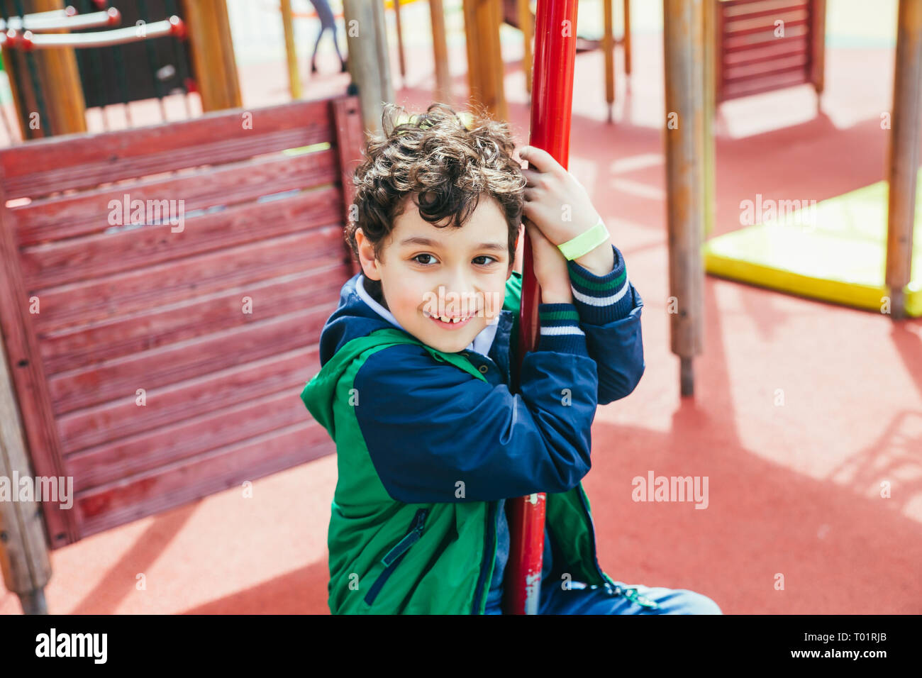 Little pretty boy is having fun outdoor. Playing in children zone in ...