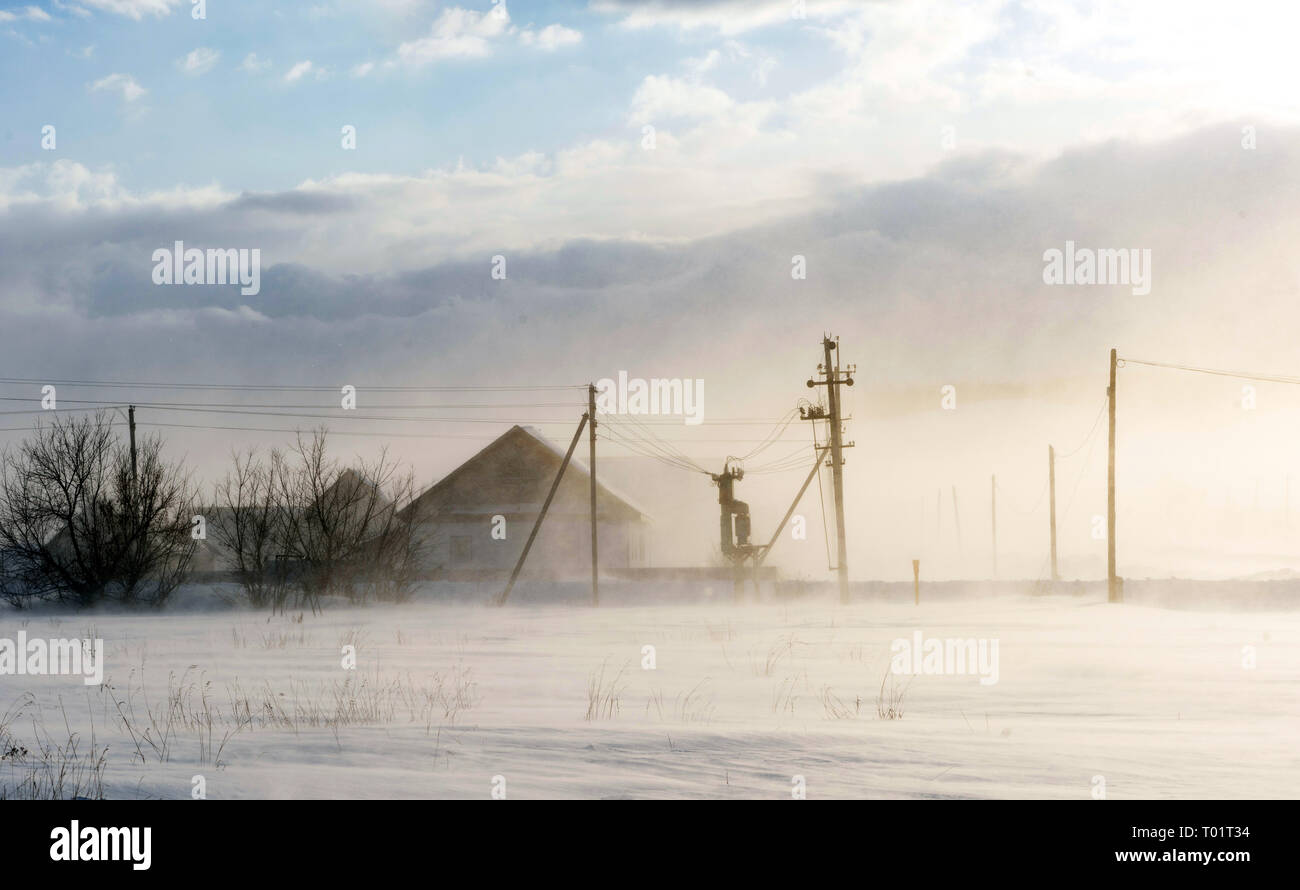 Winter snow storm and blizzard on a rural village street with houses ...